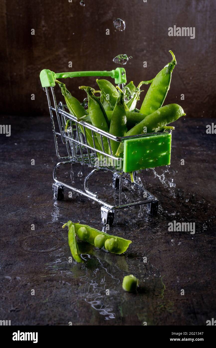 pea pods on a brown background with spray and splash of water Stock ...