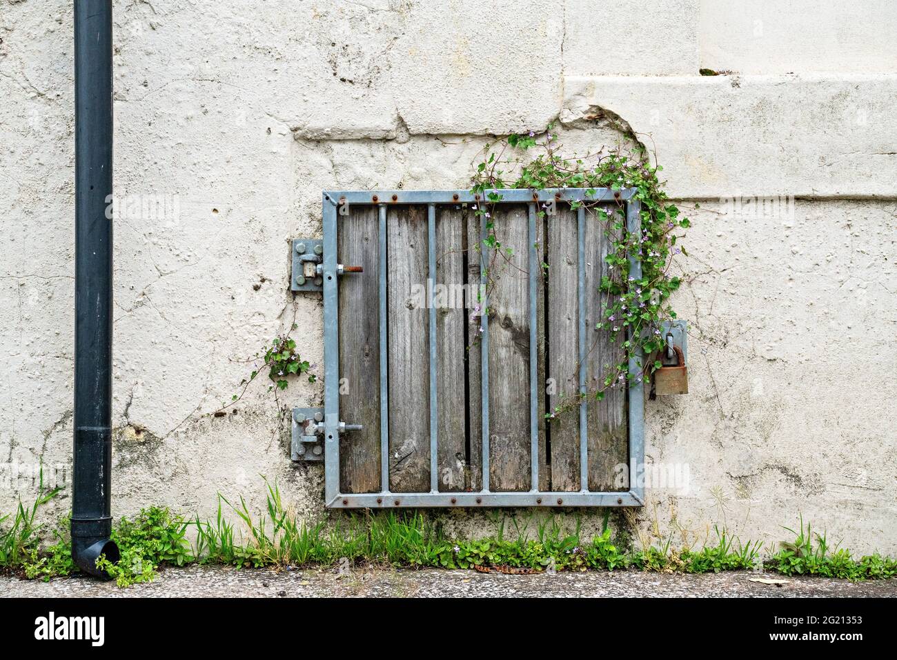 Metal bars and padlock across disused, boarded up, window Stock Photo ...