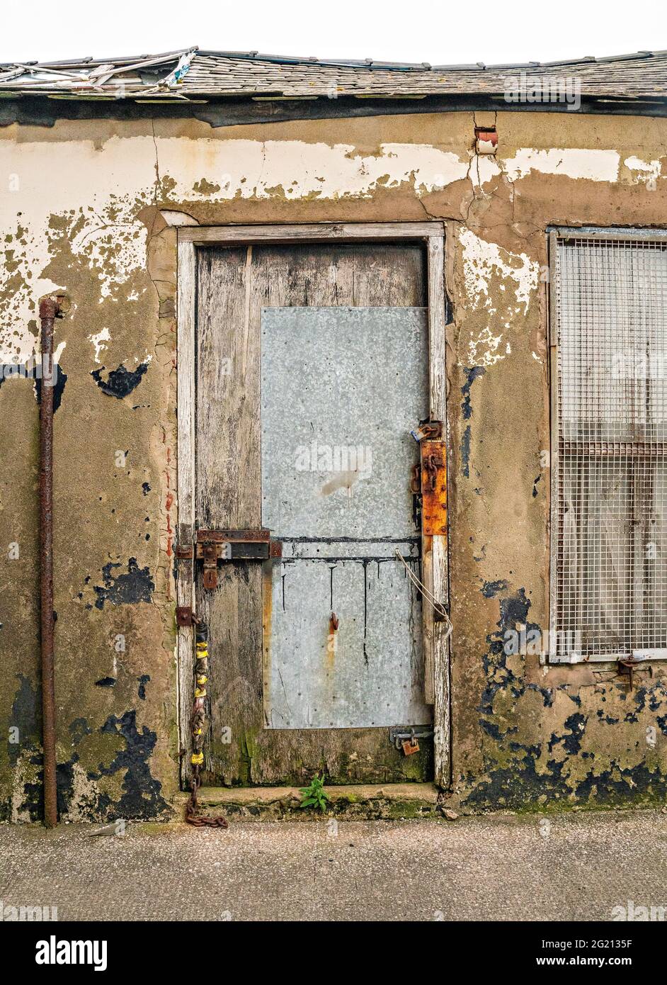 Run-down wood and metal exterior street door on derelict building Stock ...