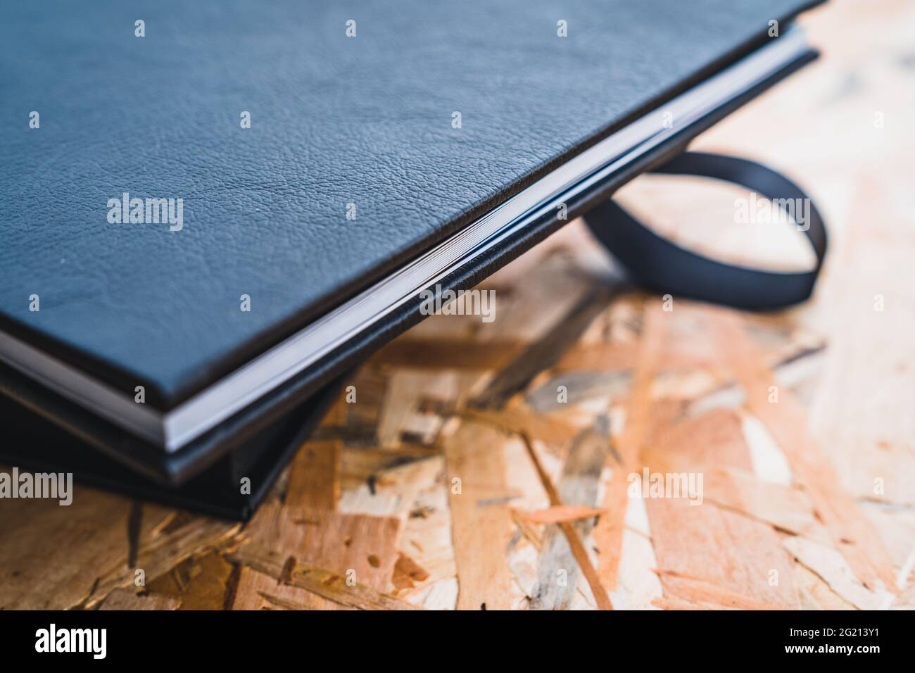 Detail of the sheets of paper of black leather photo album on a table ...