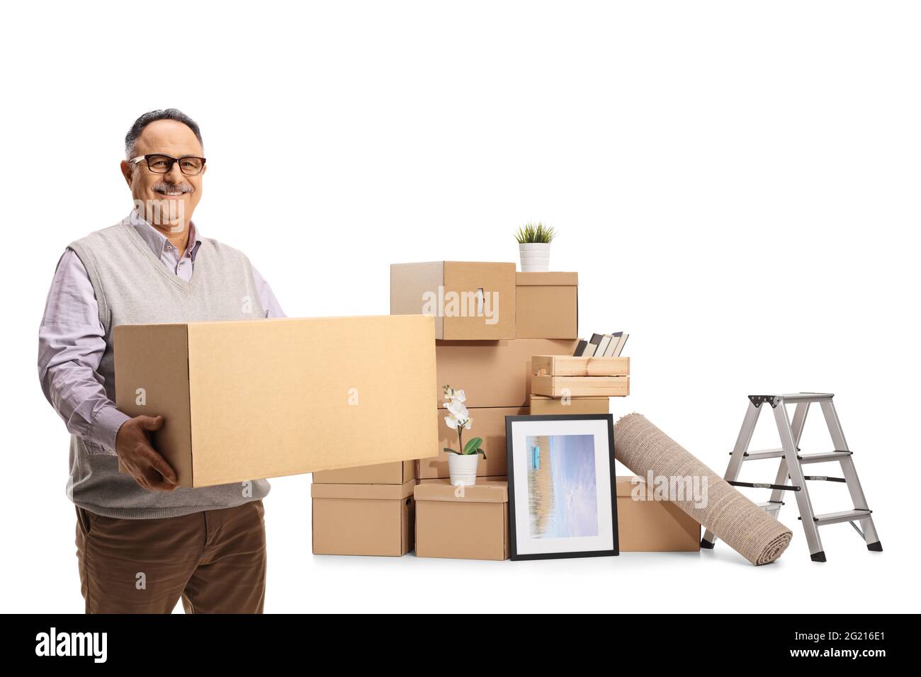 Smiling mature man packing for home removal and holding a cardboard box ...
