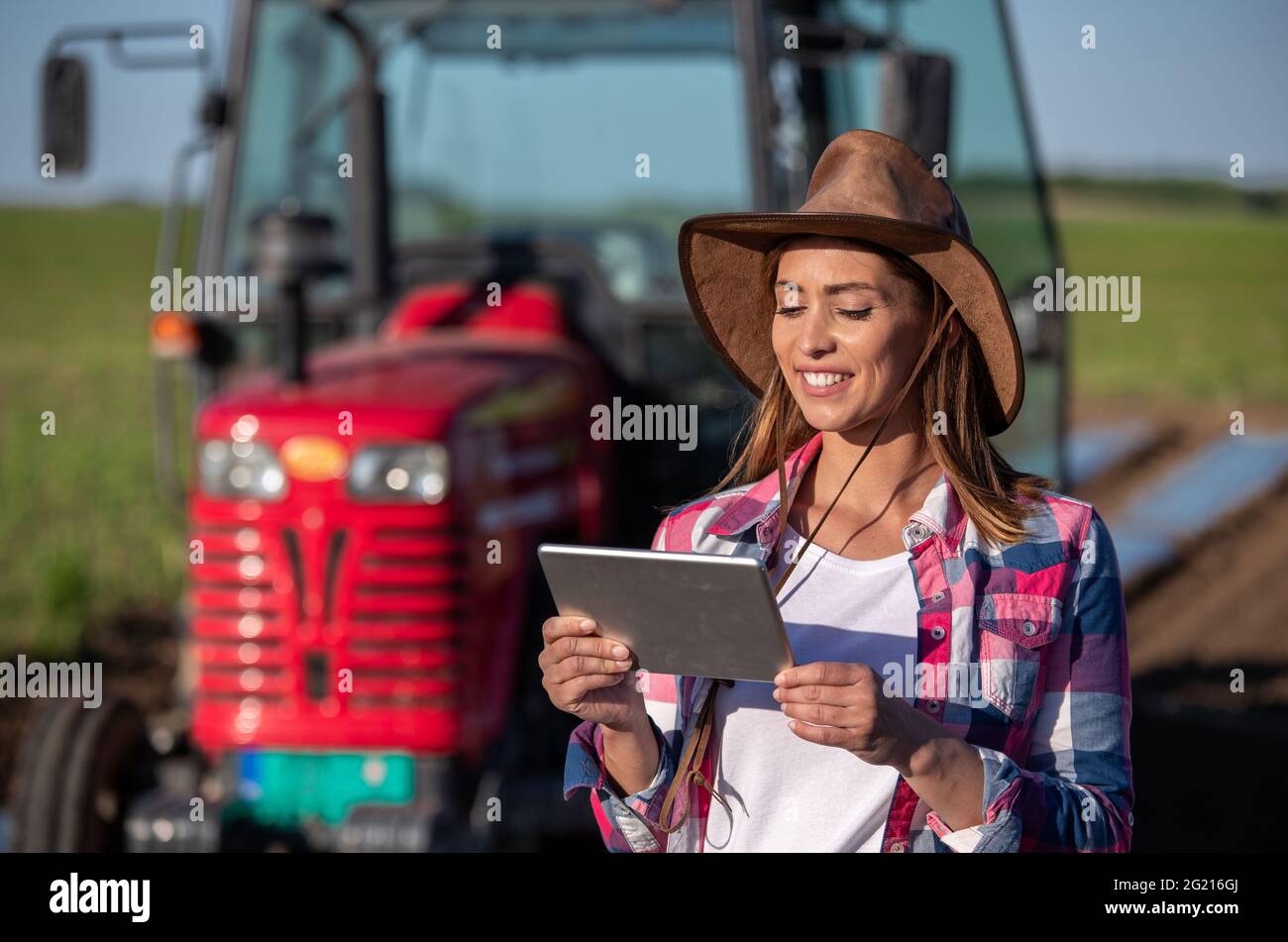 Young farmer using tablet modern technology in agriculture. Woman ...