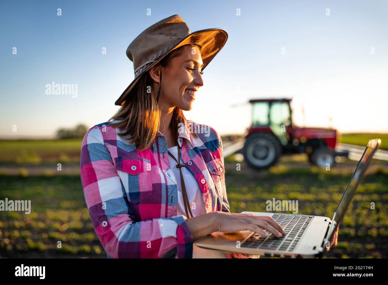 Female agronomist using laptop modern technology in agriculture. Young ...