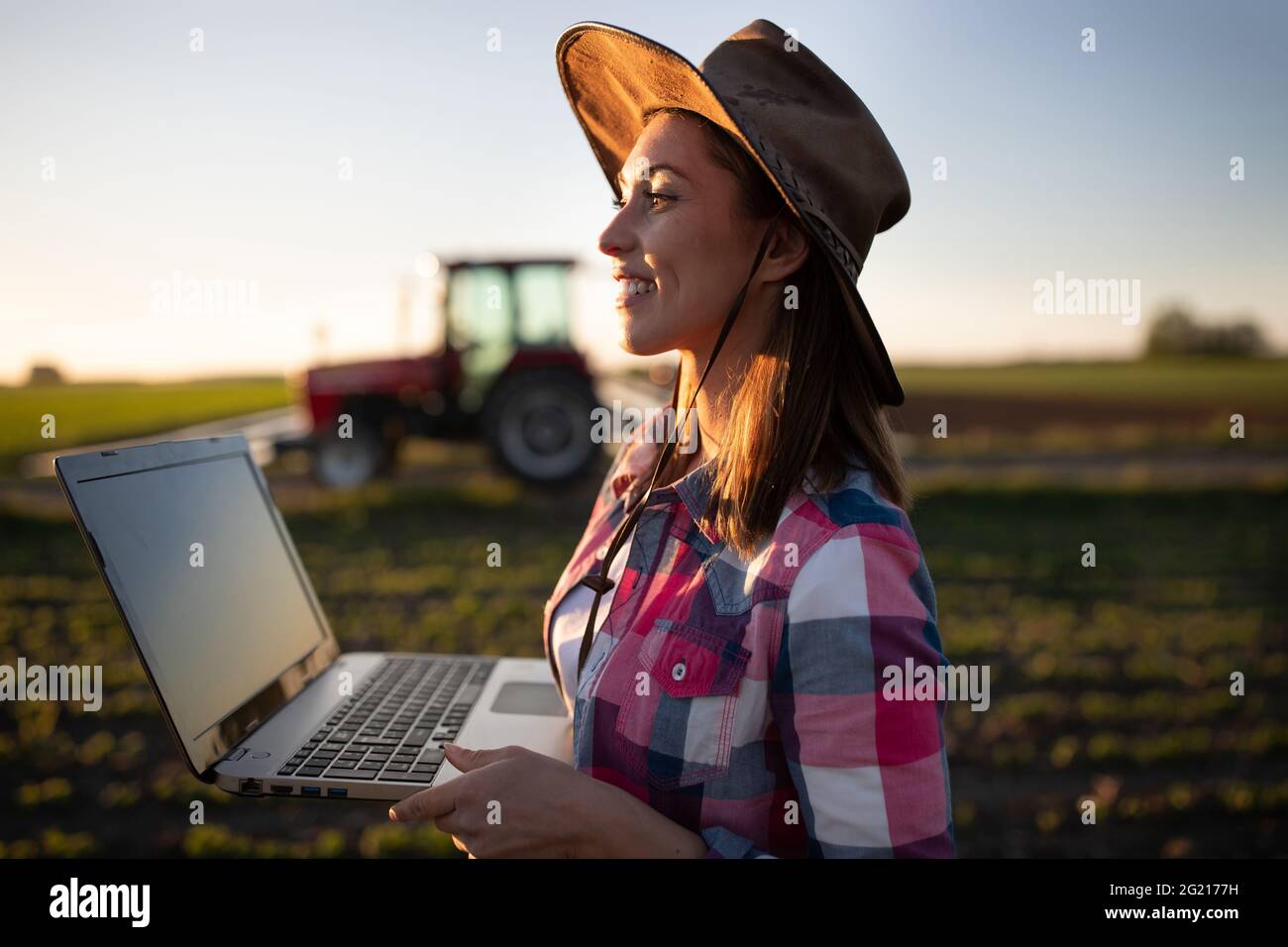 Young agronomist using computer innovation in food production. Female ...