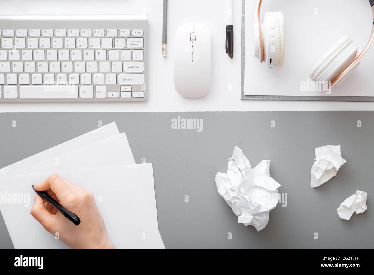 Hand writes notes on piece of paper in modern workspace. Crumpled ...