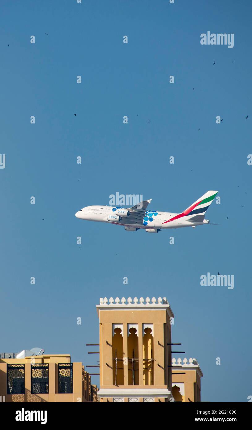 An Emirates Airlines Airbus A380 flying over a traditional wind tower ...