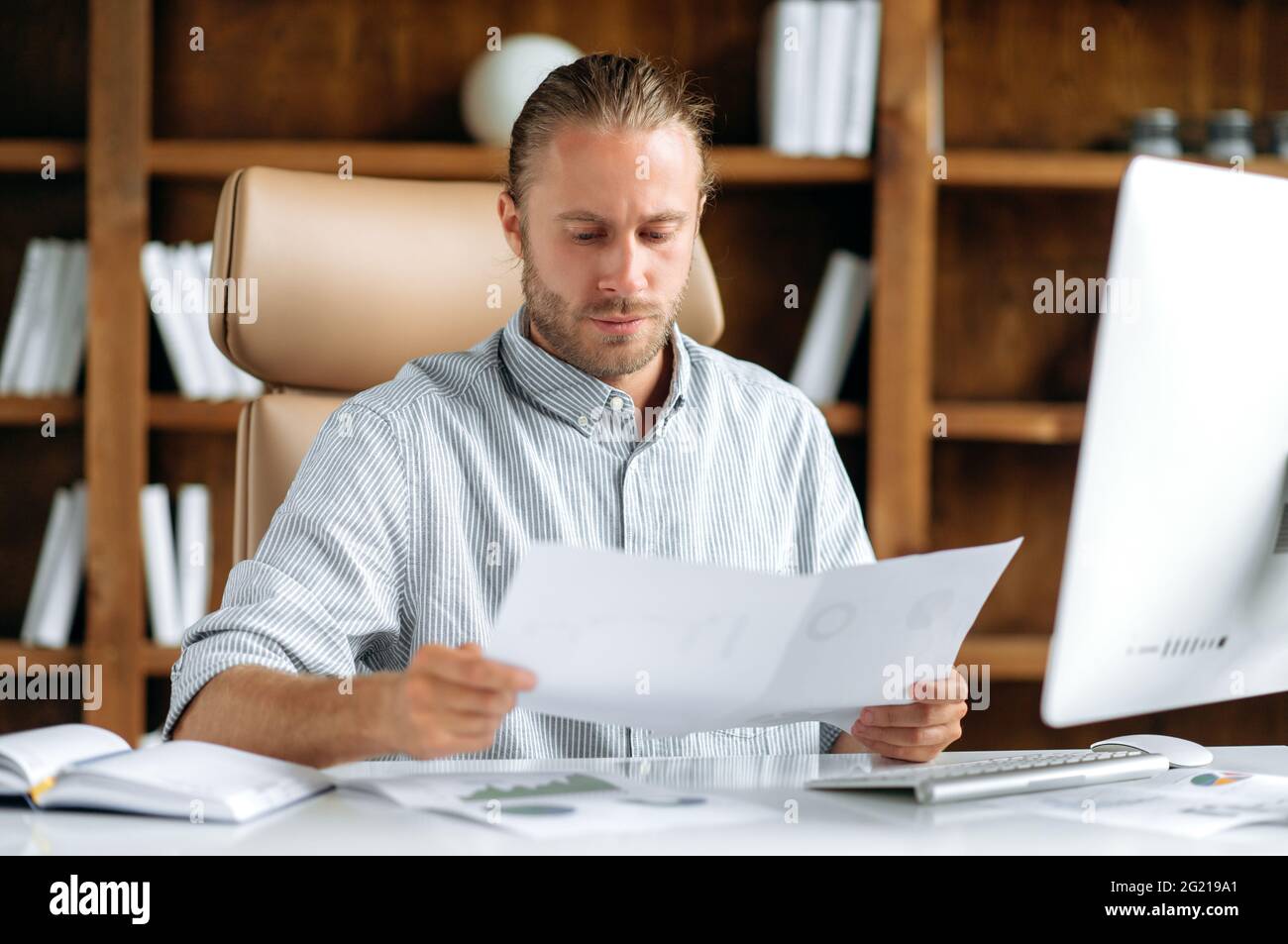 Serious focused smart caucasian manager, businessman or ceo, sitting in ...