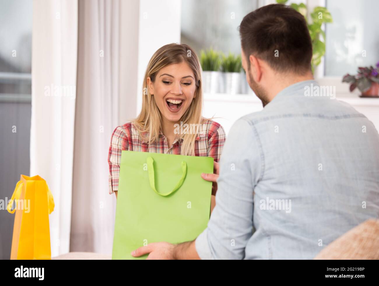 Pretty woman smiling happy getting a present. Young man giving a gift ...