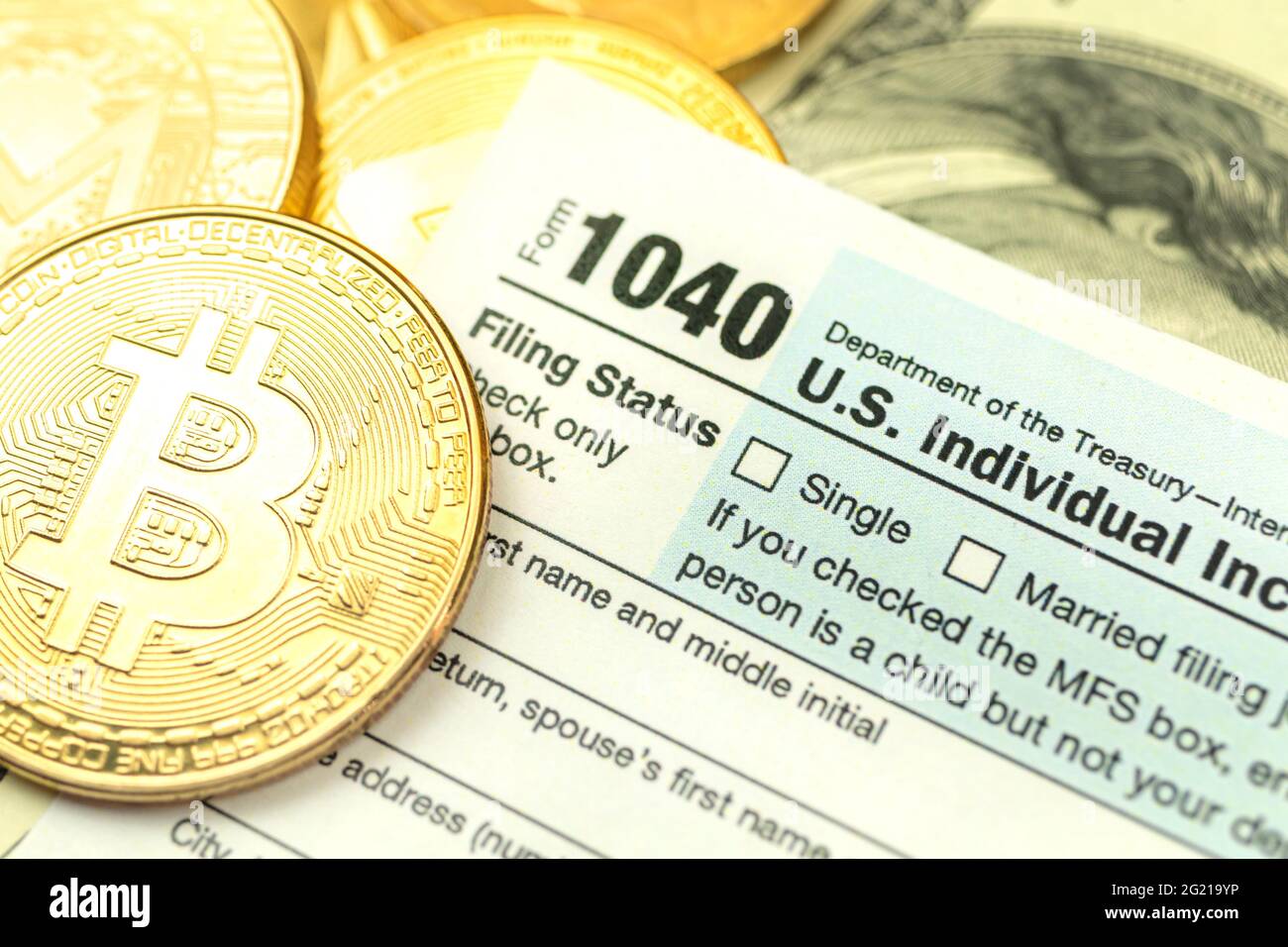 Golden bitcoin coin and tax form close-up, time to pay taxes concept ...