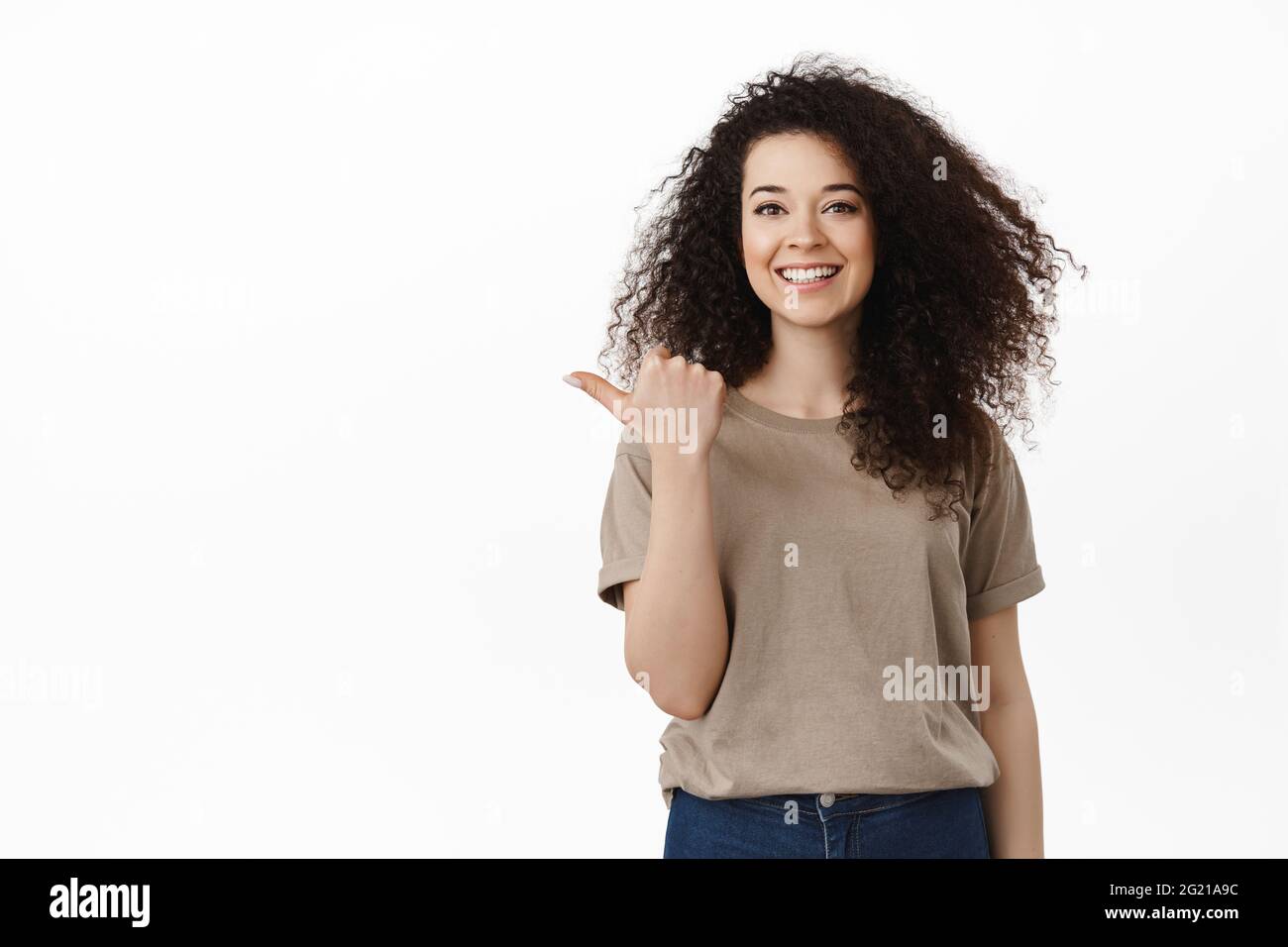 Portrait of pretty brunette woman pointing finger left at copy space ...