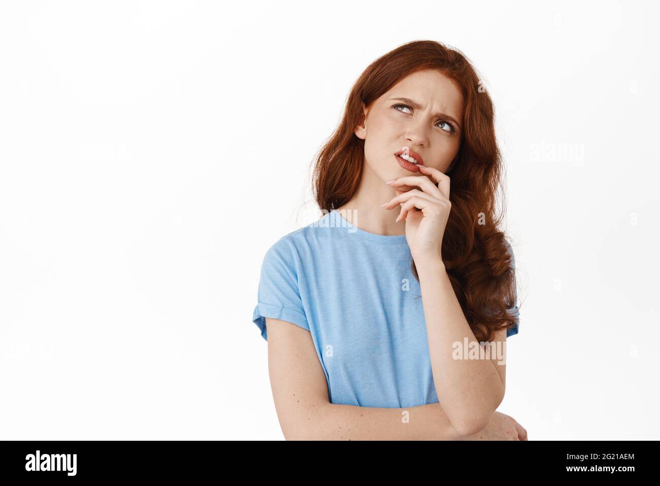 Image of thoughtful serious redhead girl, frowning and thinking ...