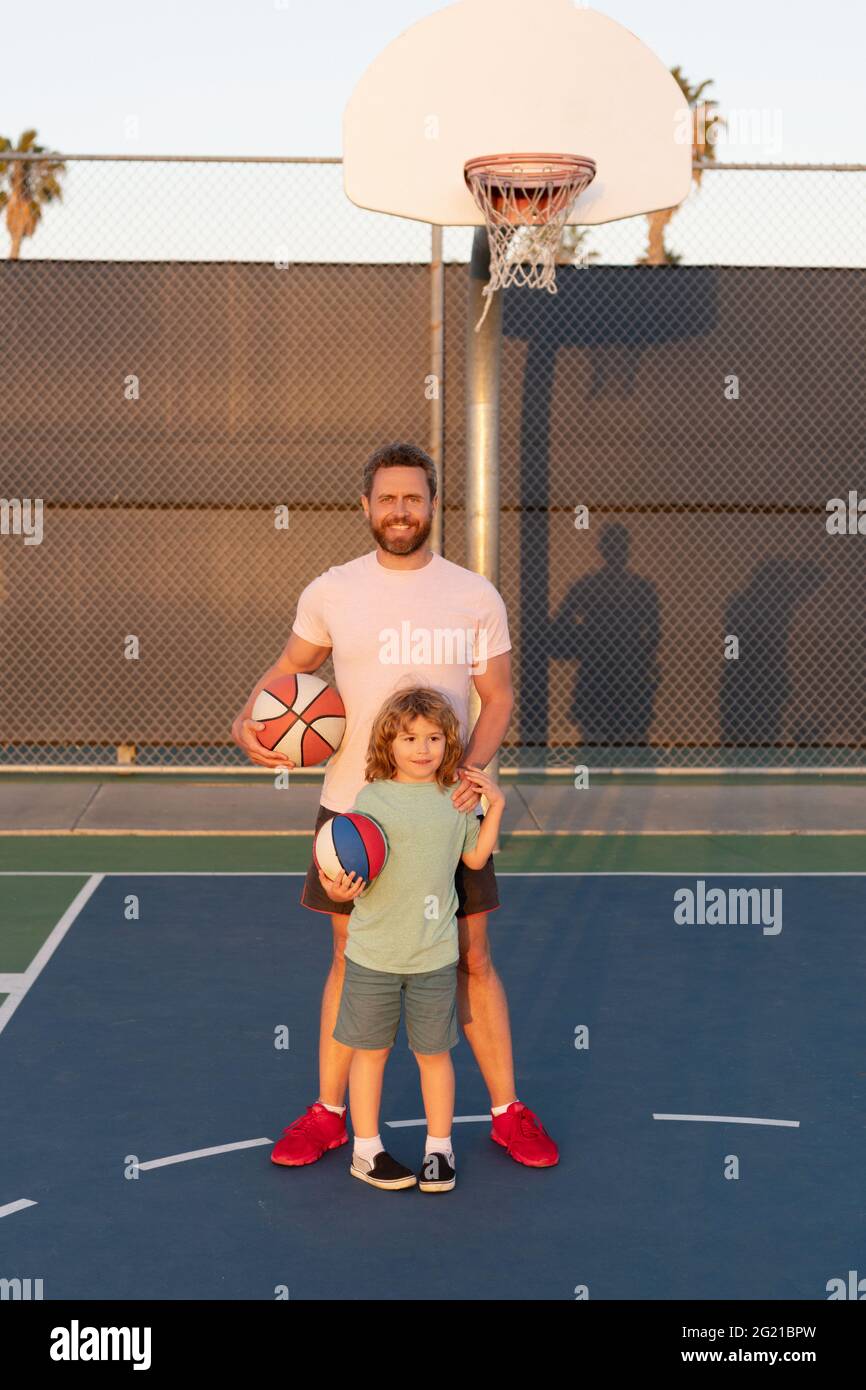 happy dad and son child play basketball with ball on playground ...
