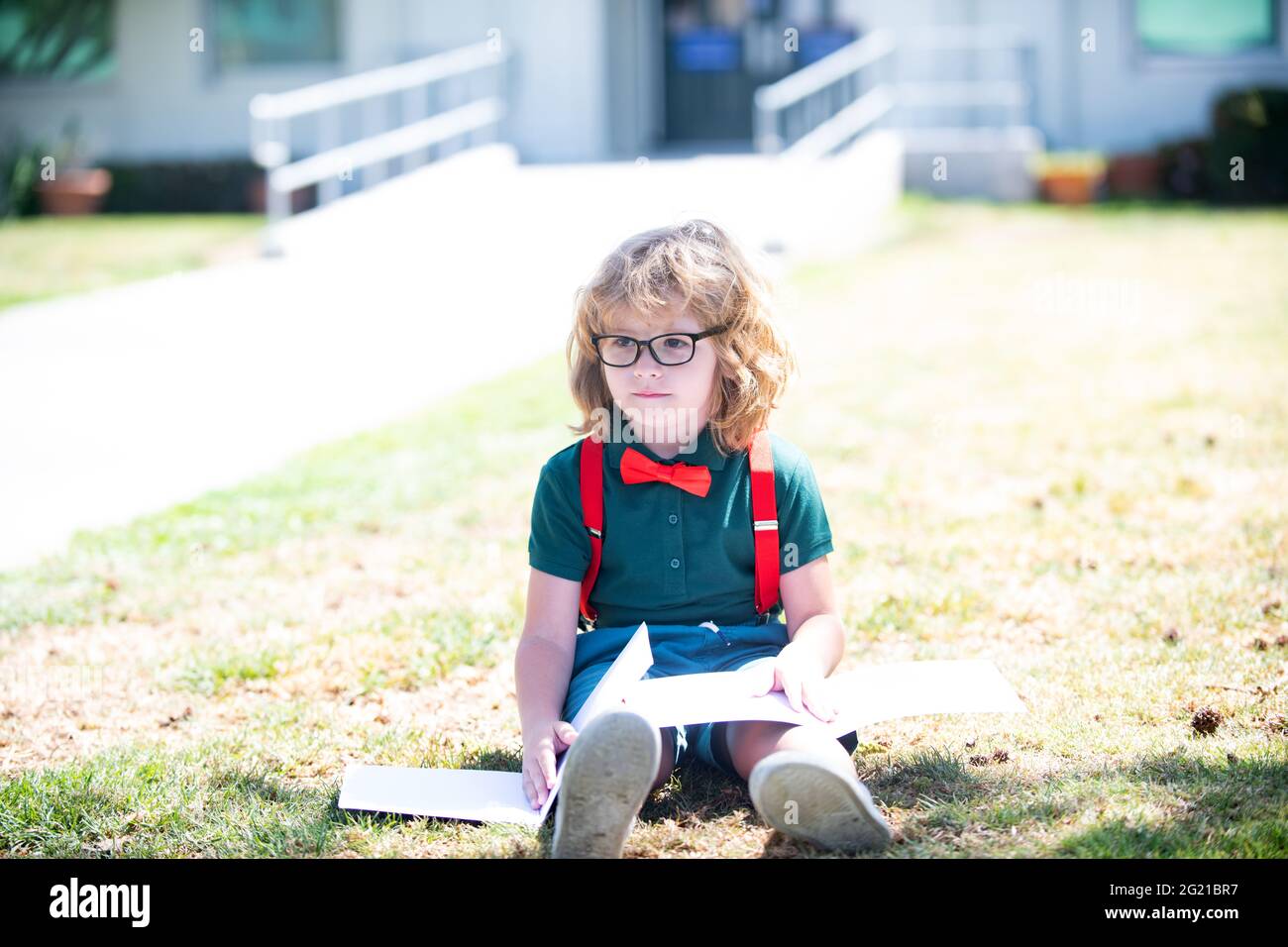 nerd in glasses. smart kid do homework with book. curious pupil reading ...