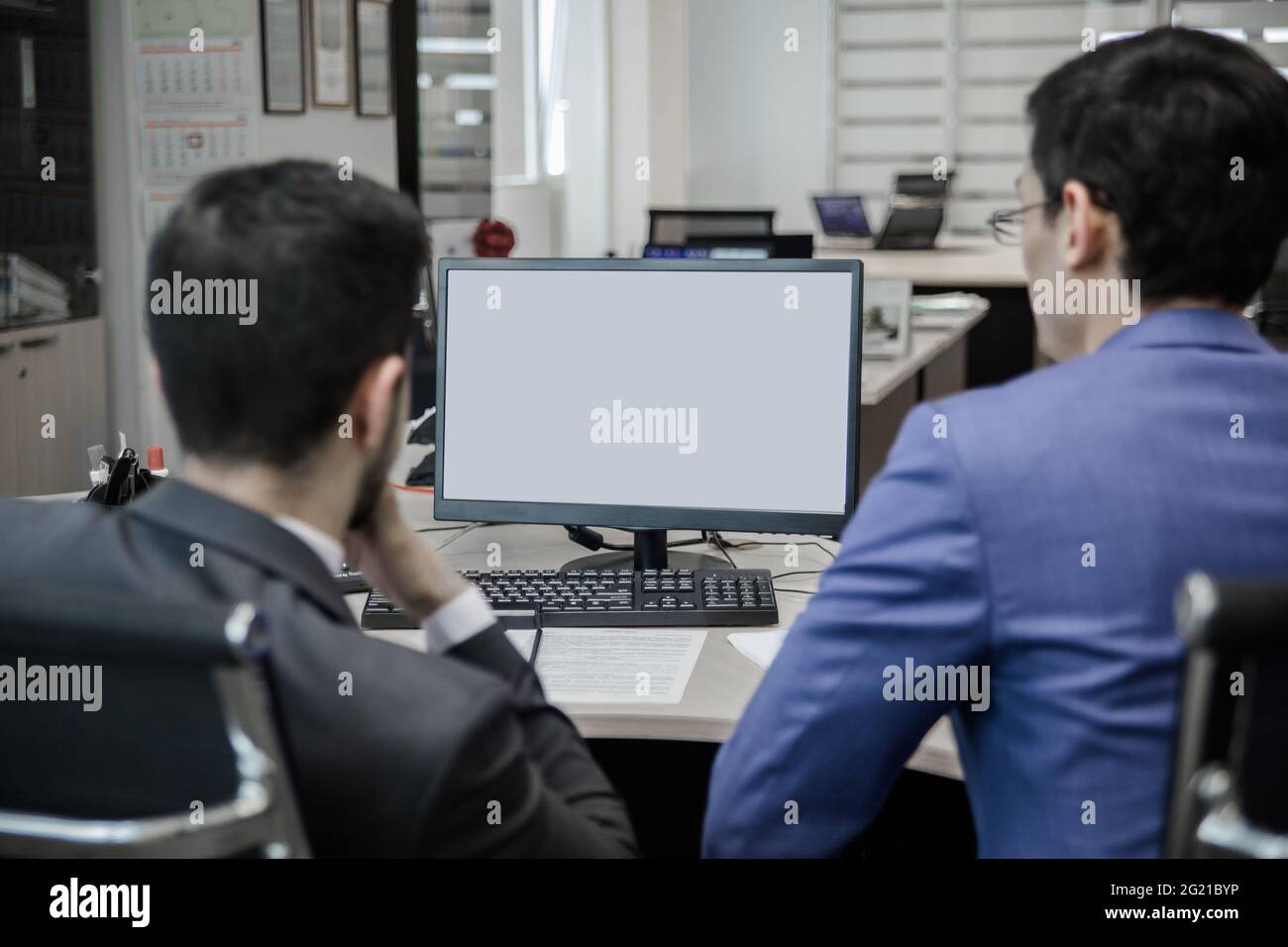 two guys at a computer in the call center behind the counter Stock ...