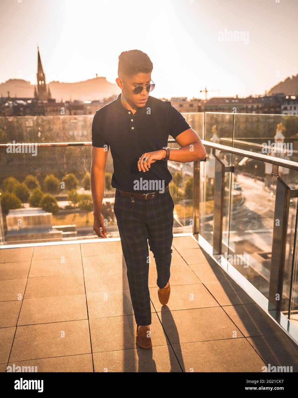 Handsome Hispanic guy in sunglasses on a balcony Stock Photo - Alamy