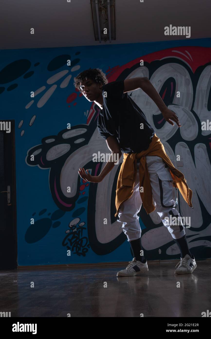 African American hip hop dancer (breakdancer) performing over graffiti ...