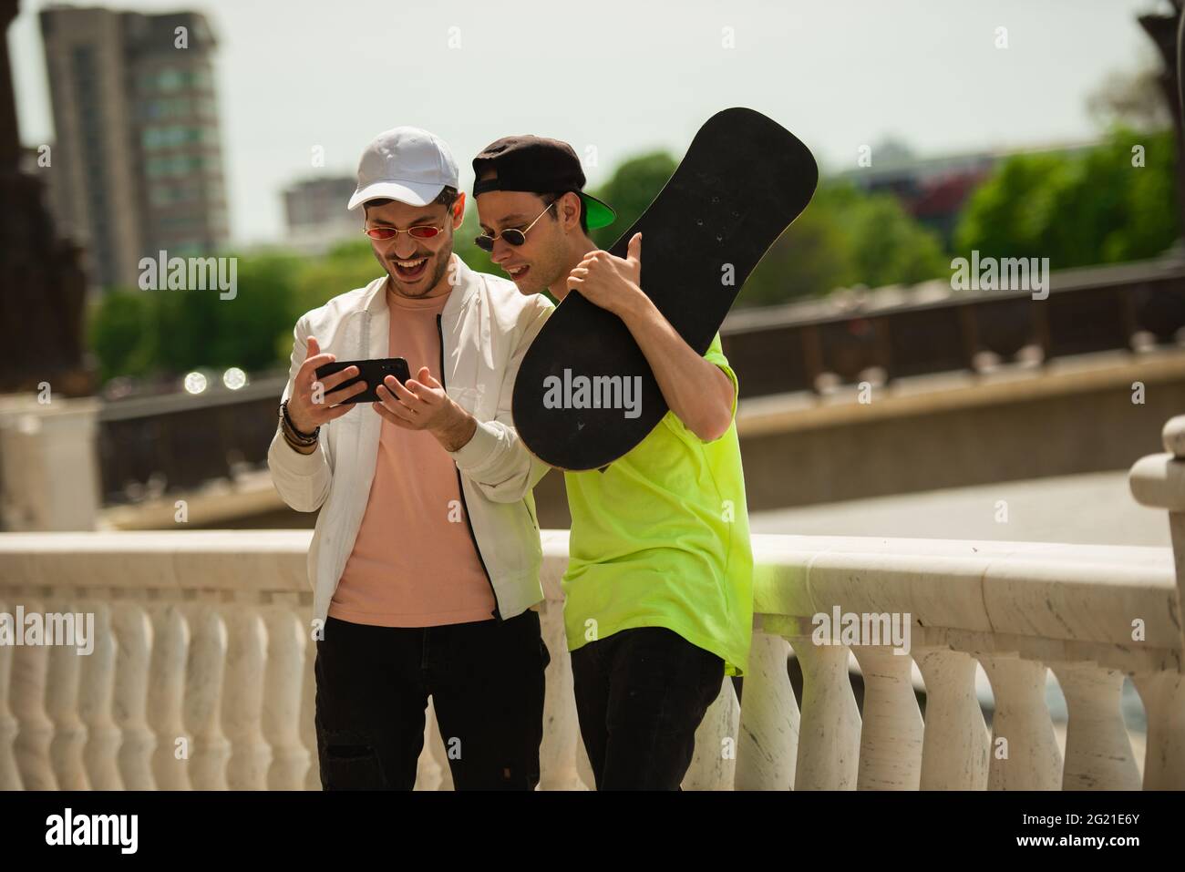 Two handsome male friends are laughing at the phone Stock Photo - Alamy