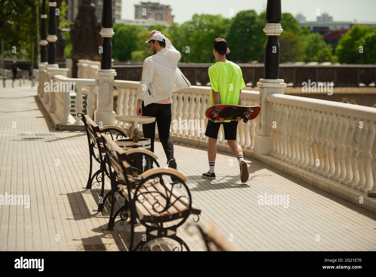 Two friends are walking together while talking Stock Photo - Alamy