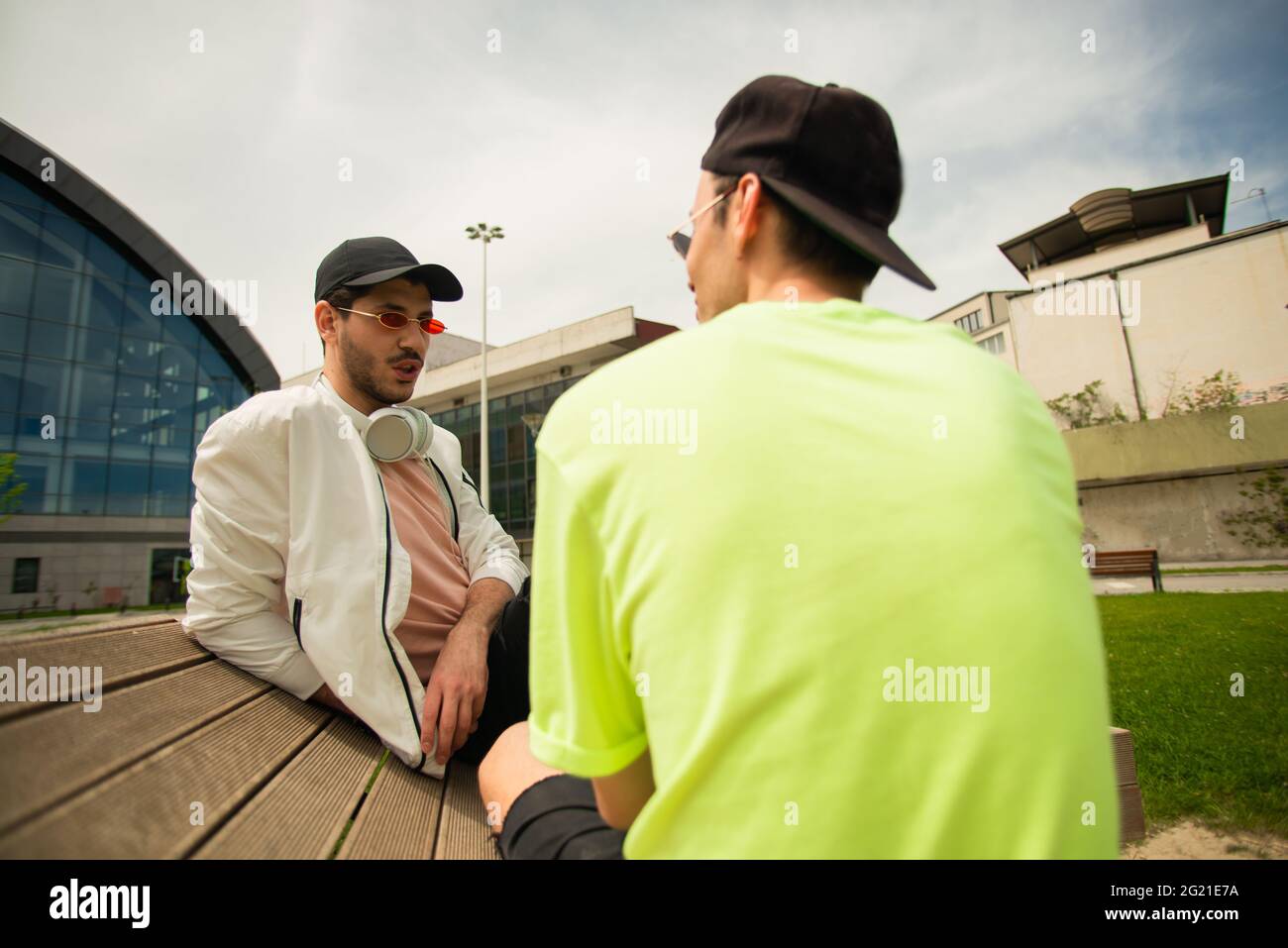 casual dressed friends are talking while sitting on the bench Stock ...