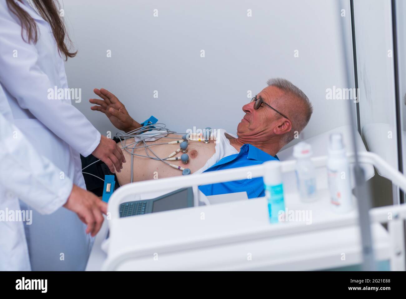 Doctor ( cardiologist ) is attaching vacuum sensors to an elder ...