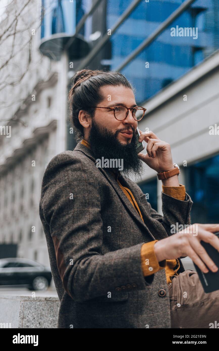 Stylish caucasian male clothed in a fashionable outfit making a phone ...