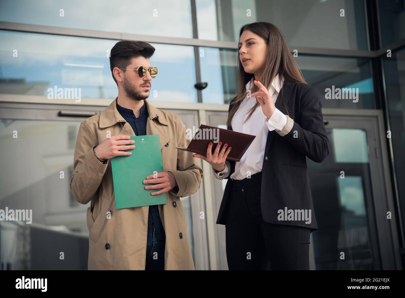 Two business people are having a conversation about the plans in front ...