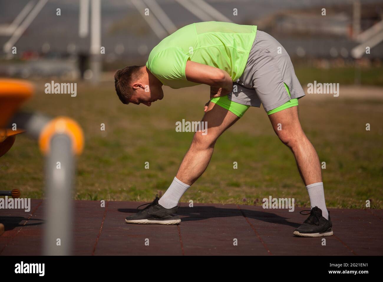 Handsome and attractive guy is stretching his back and legs before his ...