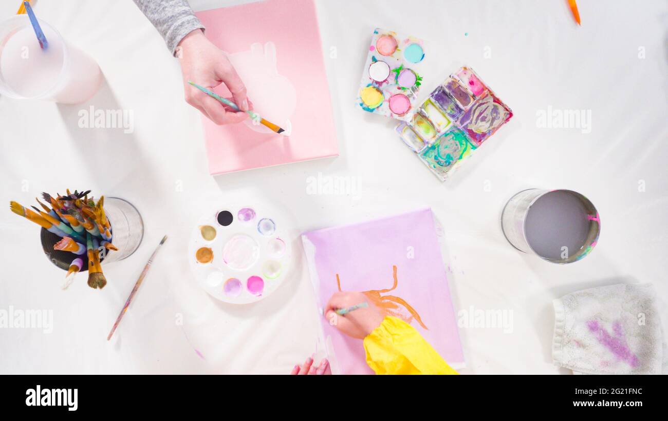 Flat lay. Little girl painting with acrylic paint on canvas with her ...