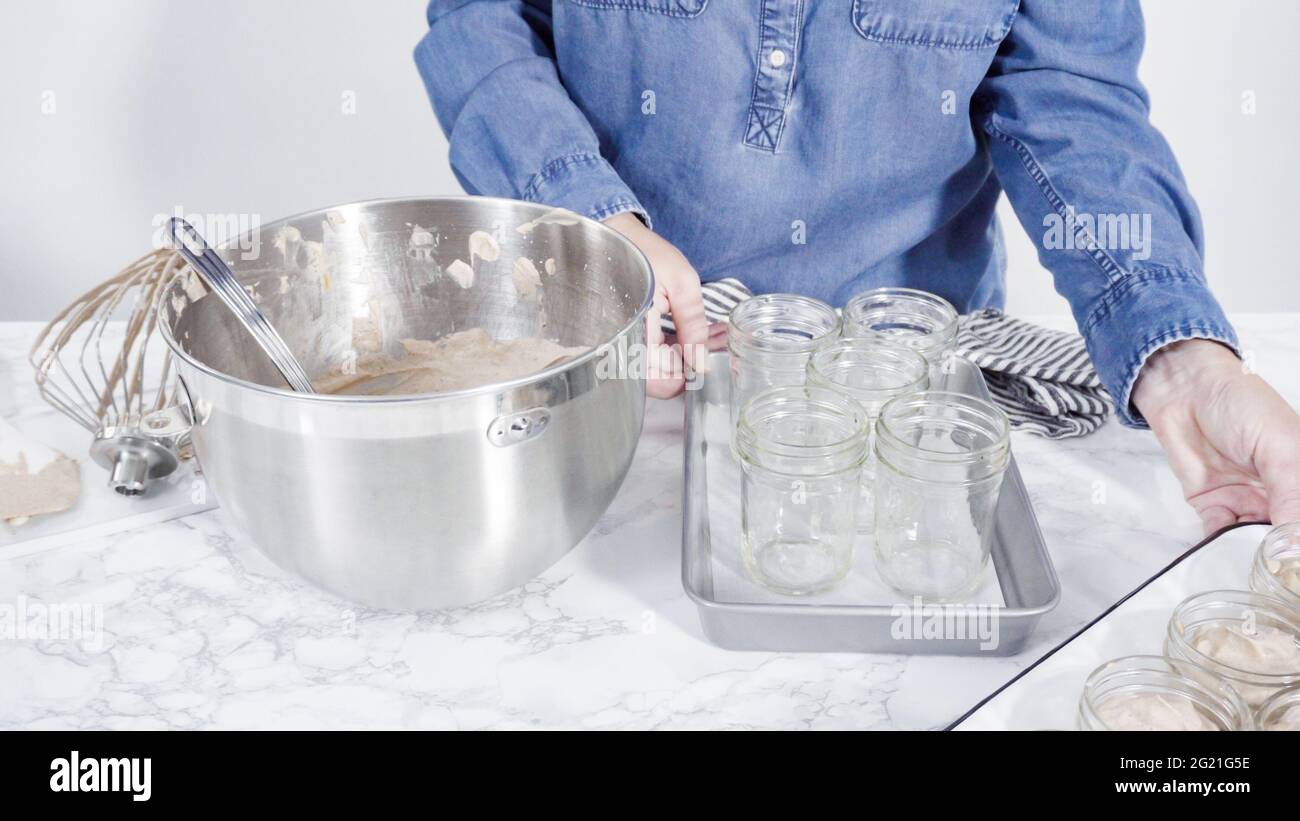 Step by step. Scooping homemade chocolate ice cream into glass jars ...