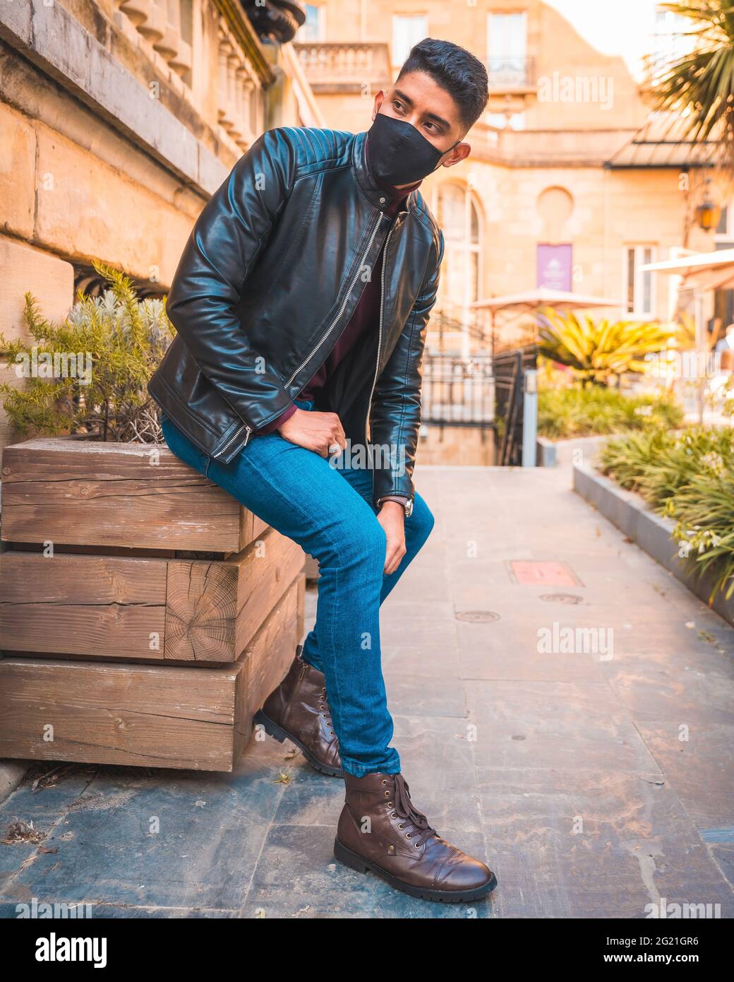 Vertical shot of a Hispanic male posing in a city in a face mask Stock ...