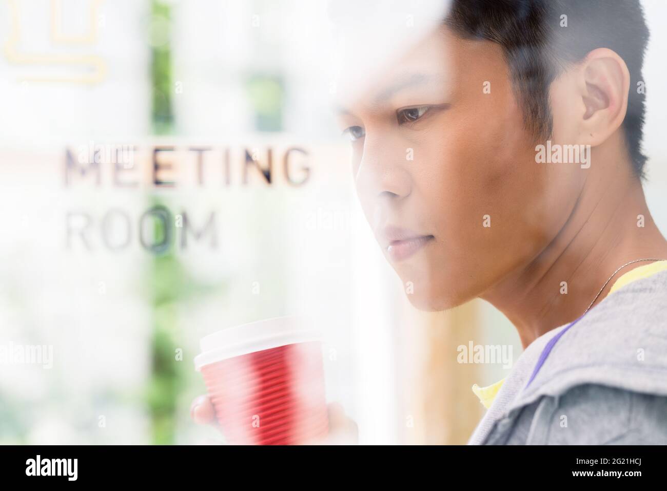 Portrait of creative young Asian employee smiling while thinking of ...