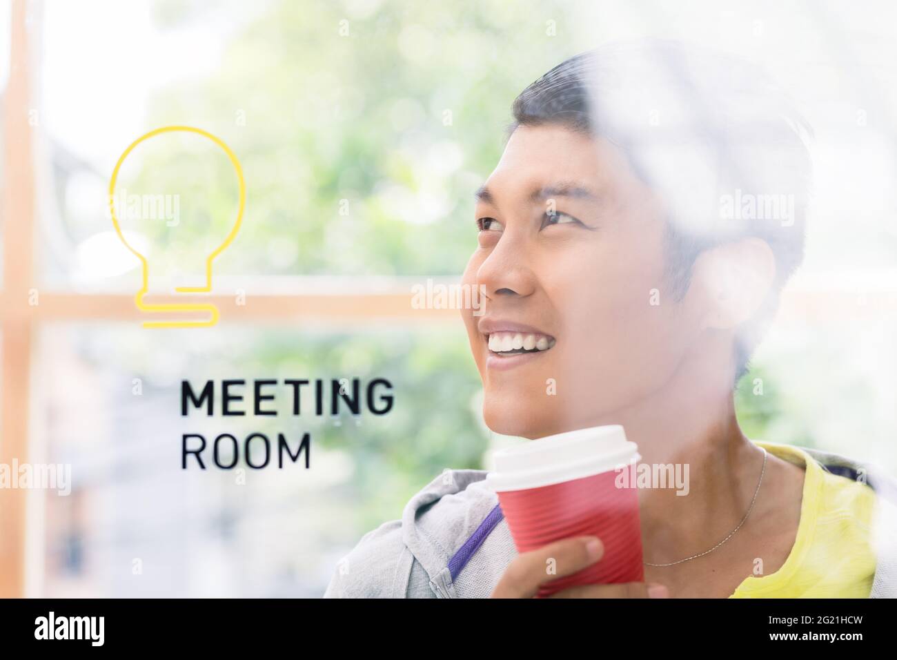 Portrait of creative young Asian employee smiling while thinking of ...