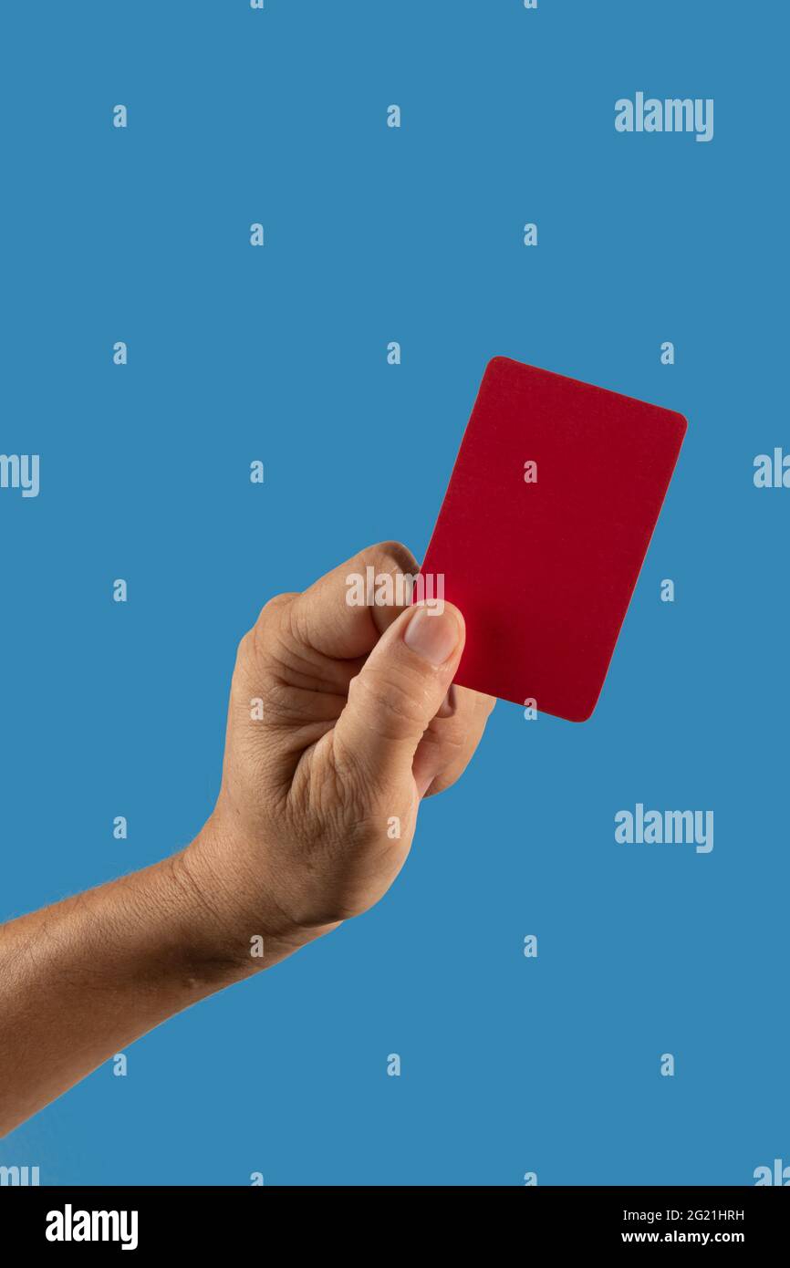 referee hand holding red punishment card on blue background Stock Photo ...