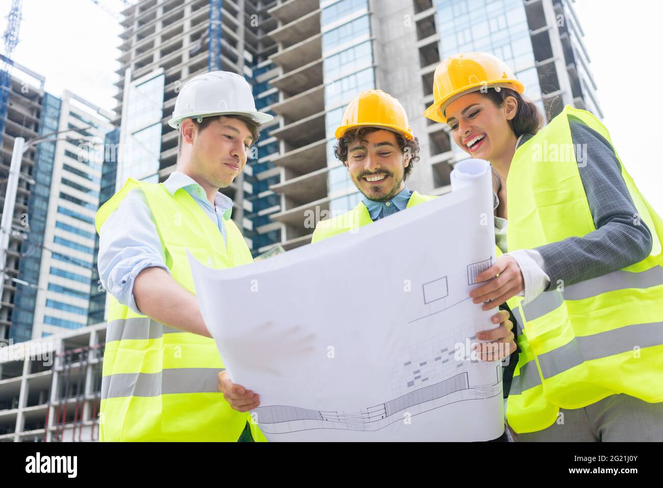 Architects and civil engineers with ground plot on construction site of ...