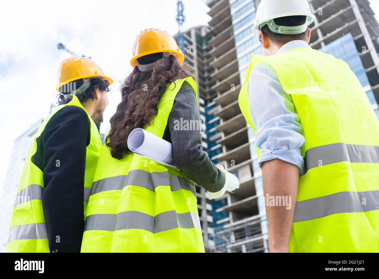 Construction engineers or architects at building site of highrise ...