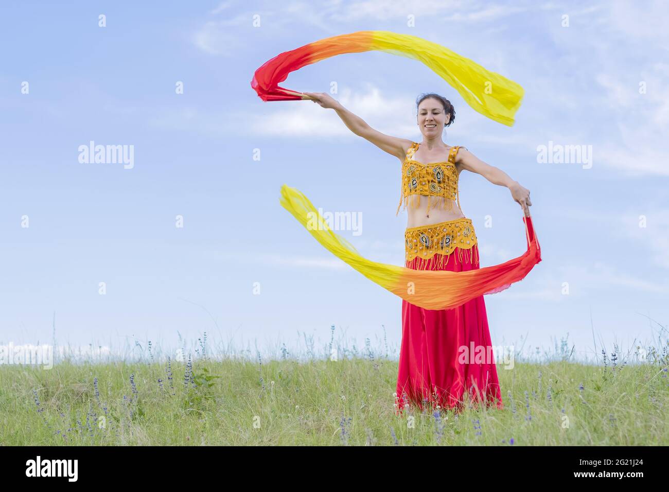 A young woman in a national costume is dancing an oriental dance in the ...