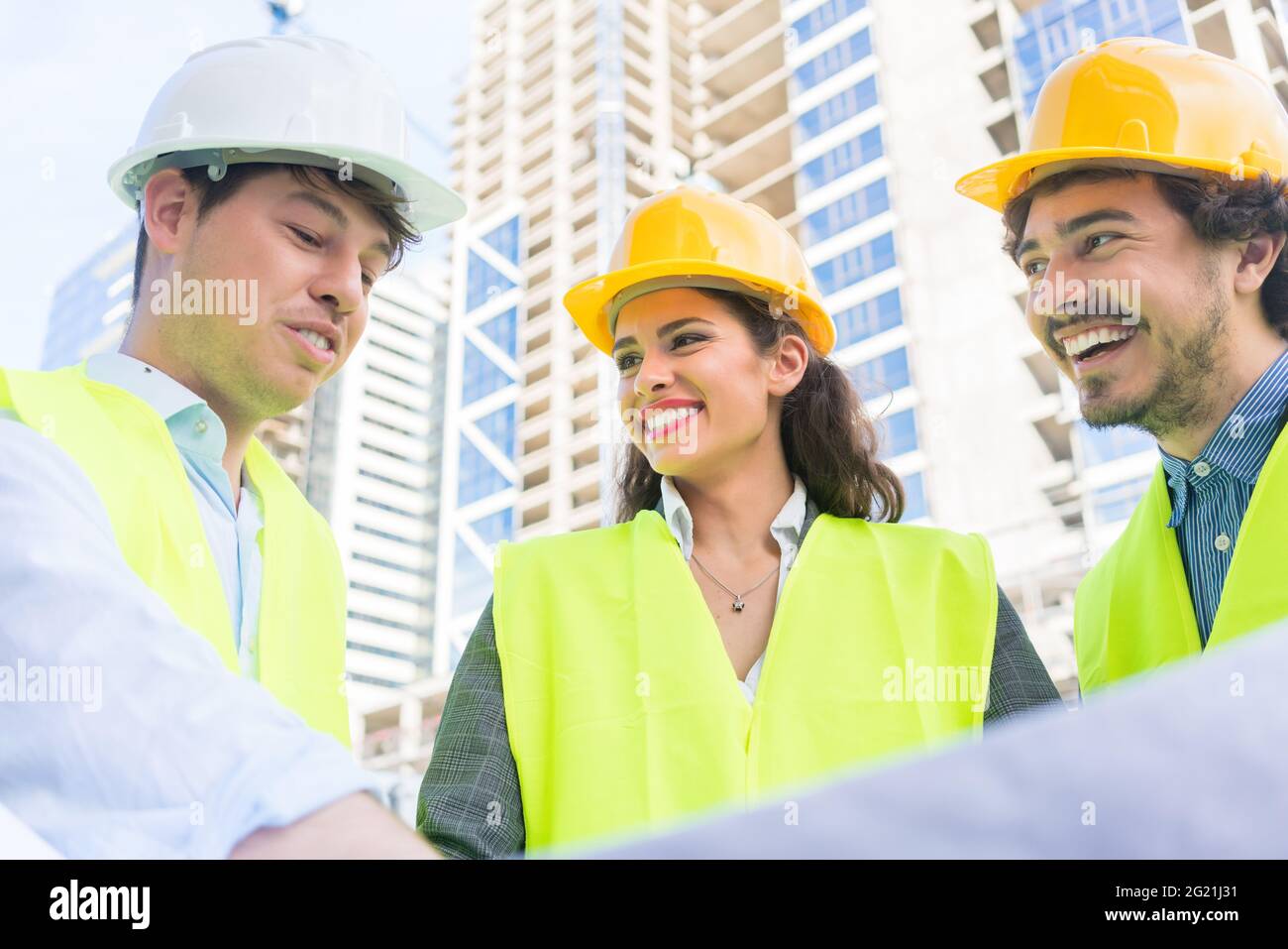 Architects and civil engineers with ground plot on construction site of ...