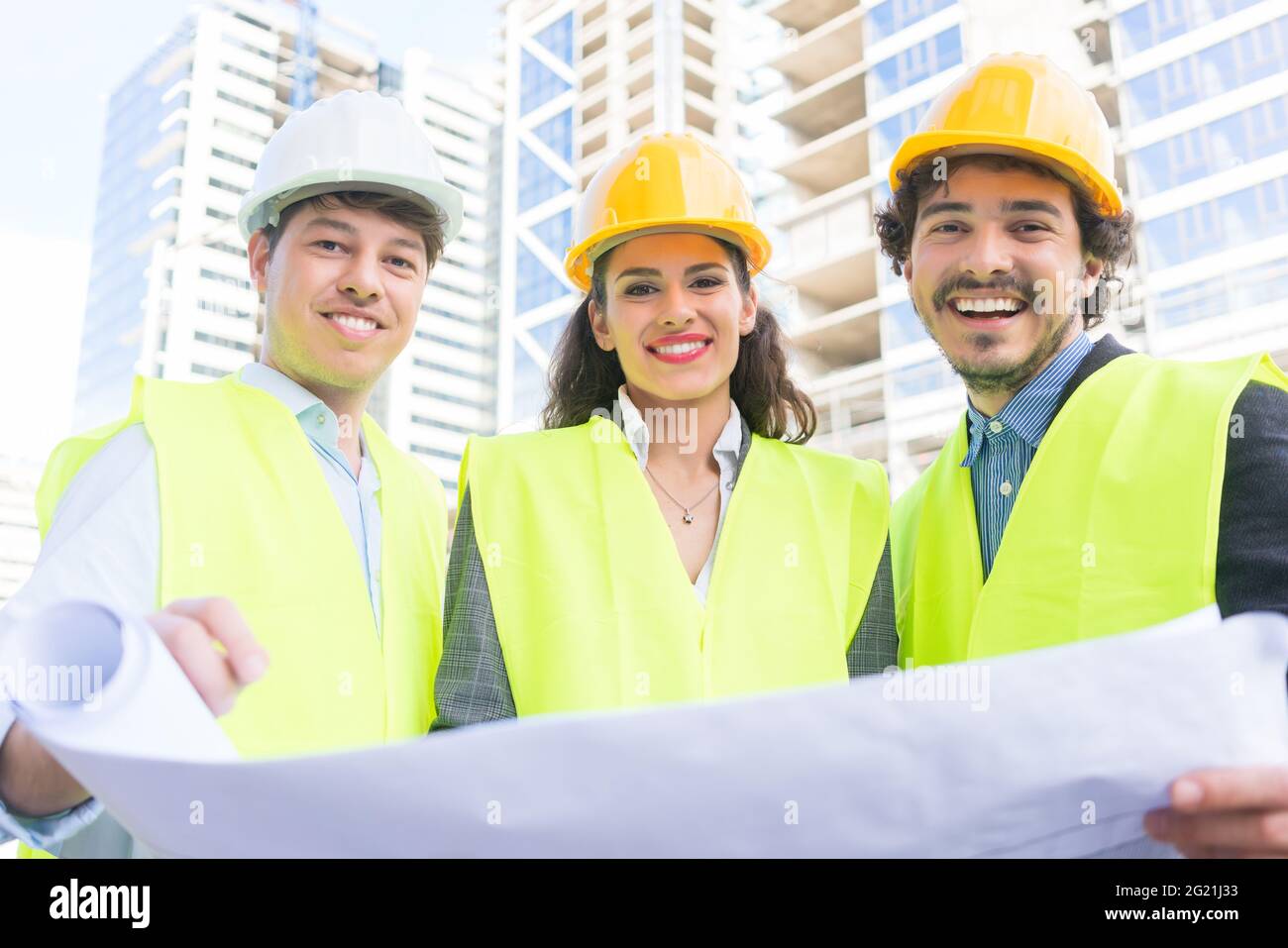 Architects and civil engineers with ground plot on construction site of ...