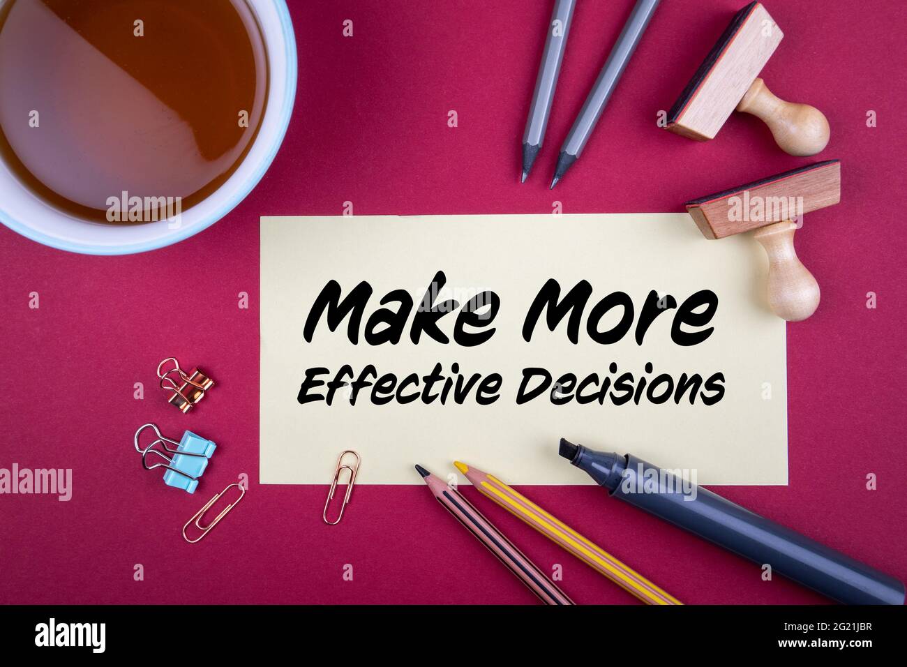 Make More Effective Decisions. Red background with office supplies ...