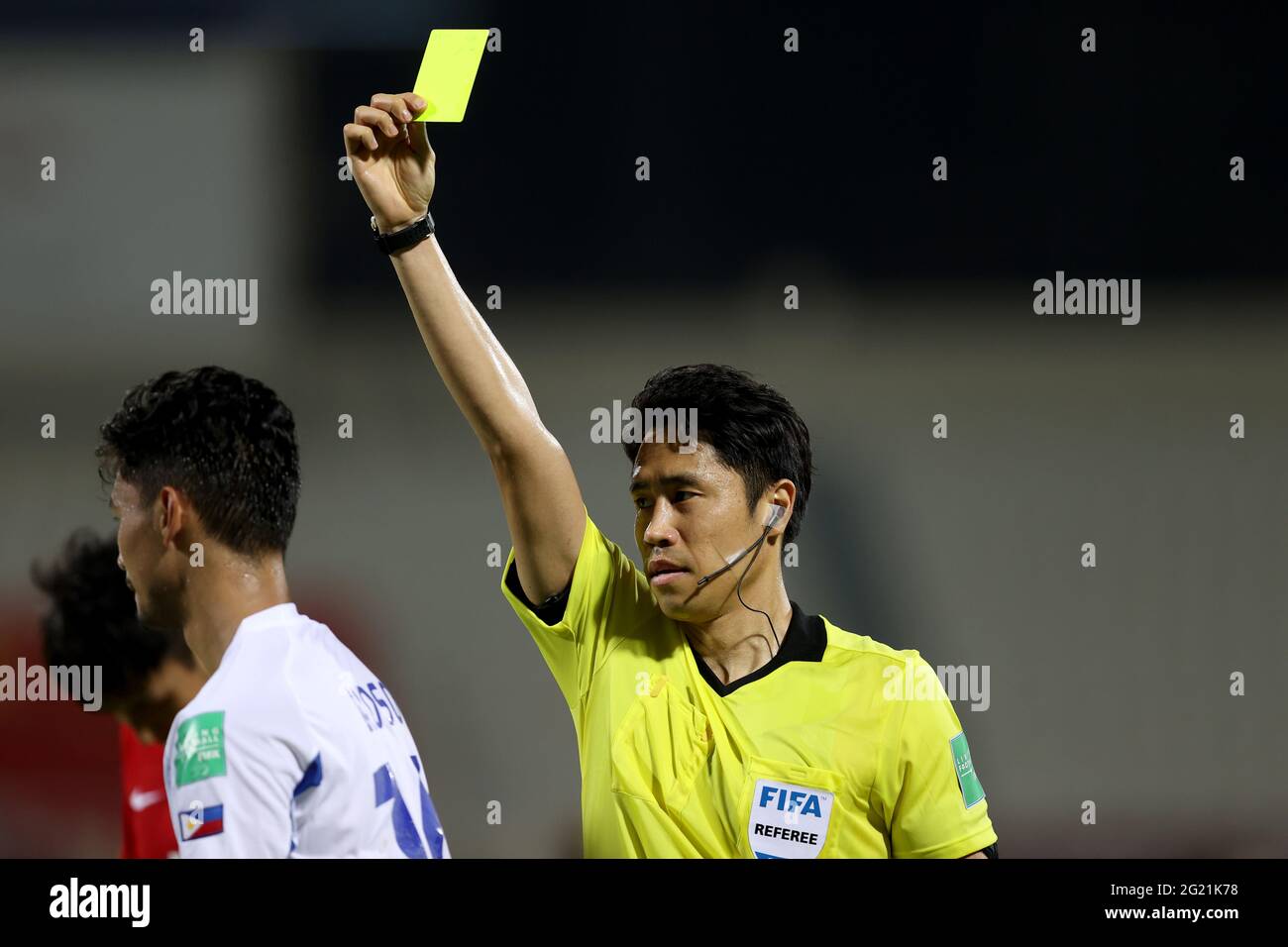 Sharjah. 8th June, 2021. Referee Kim Heegon (R) of South Korea shows a ...