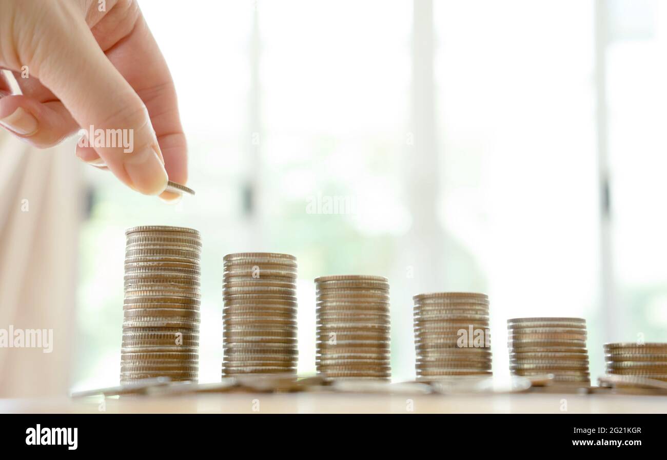 woman put coins to stack of coins Stock Photo - Alamy