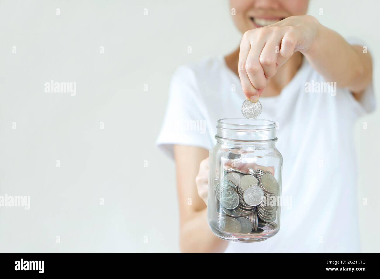 Woman hands with coins in glass jar Stock Photo - Alamy