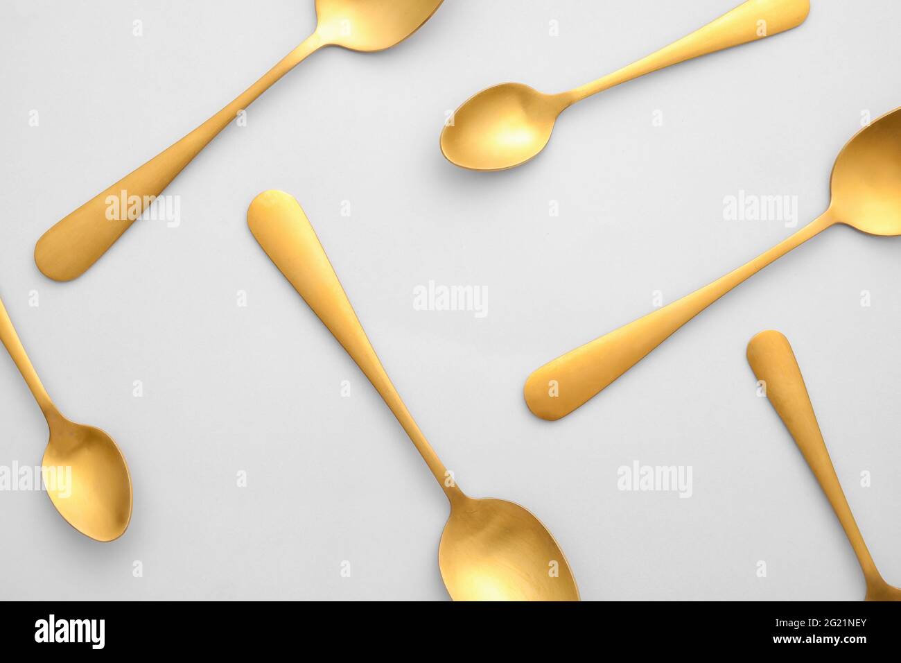 Clean spoons on grey background Stock Photo - Alamy