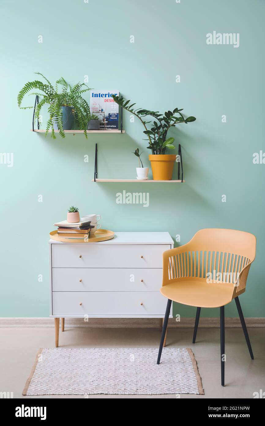 Interior of modern room with chest of drawers, chair and shelves Stock ...