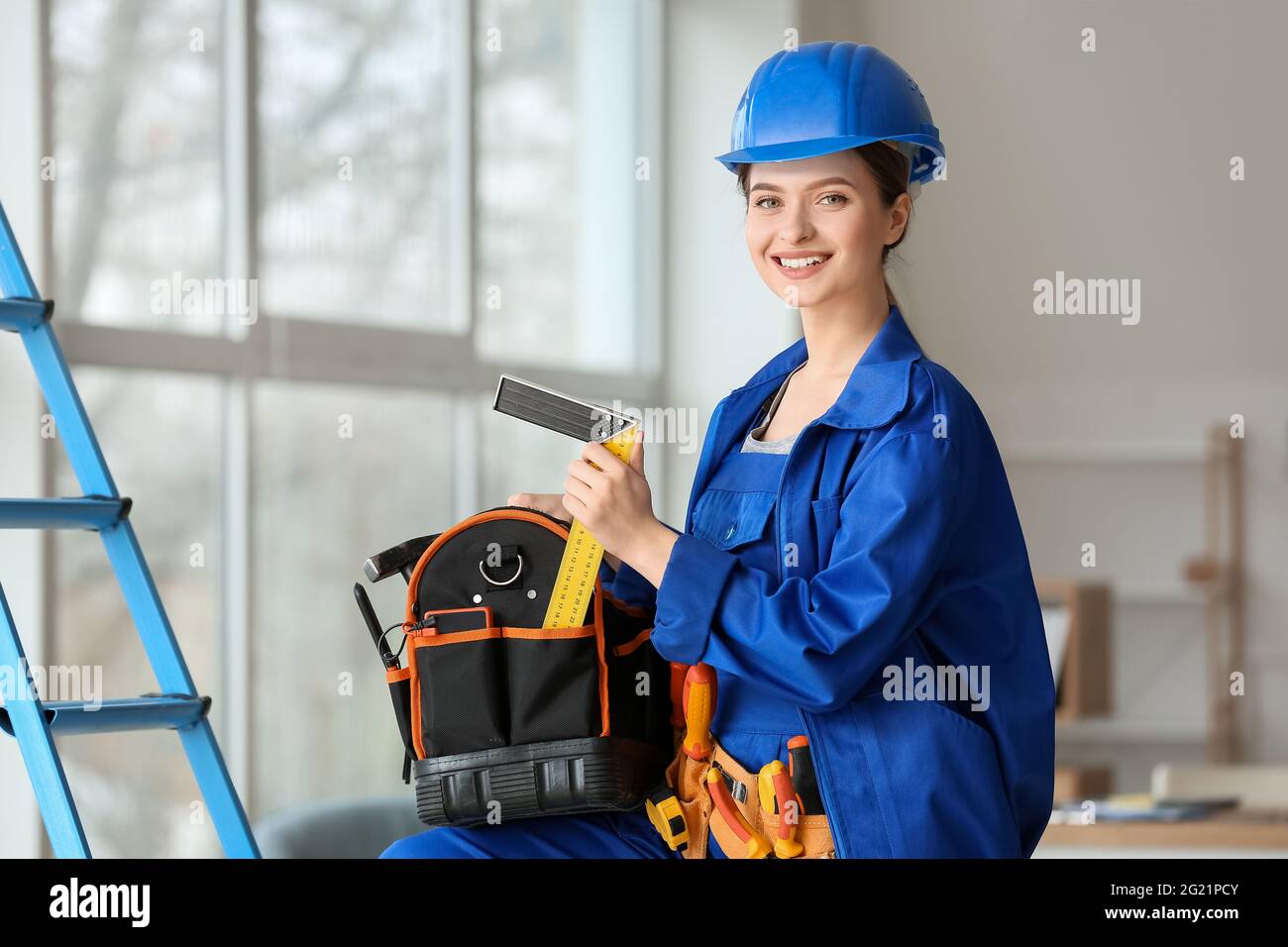 Beautiful female electrician with tools in room Stock Photo - Alamy