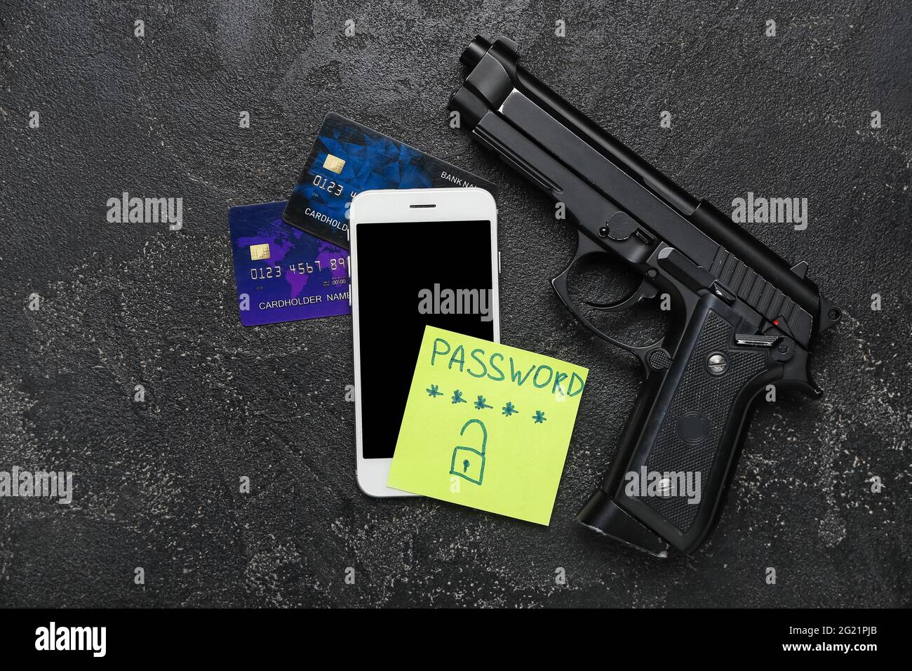 Cell phone, gun, credit cards and paper with text PASSWORD on dark ...