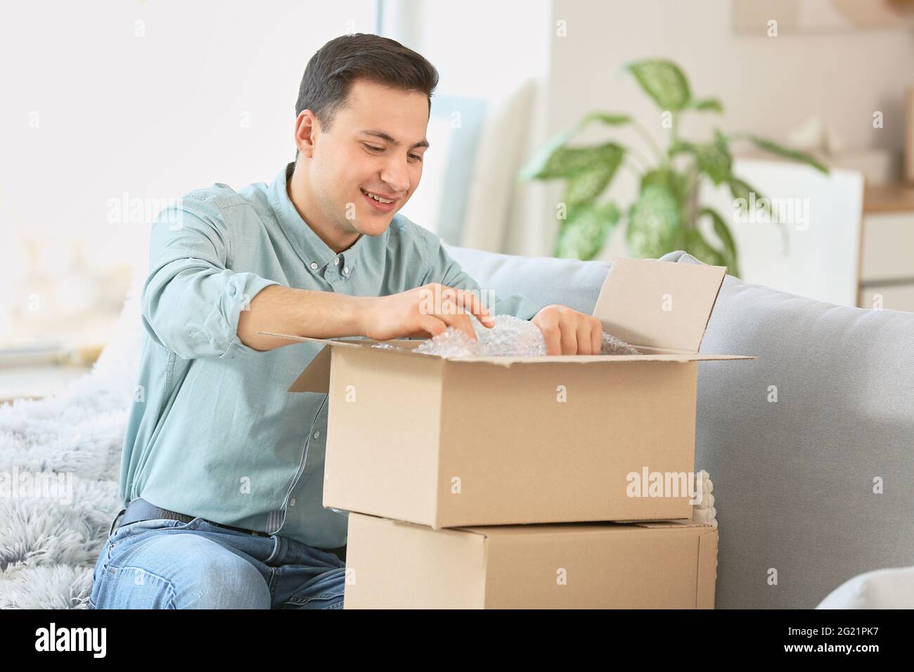 Happy man unpacking delivery parcel hi-res stock photography and images ...