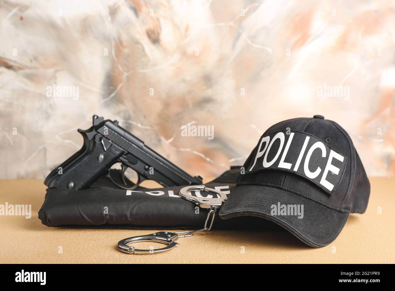Uniform of policeman with gun and handcuffs on color background Stock ...