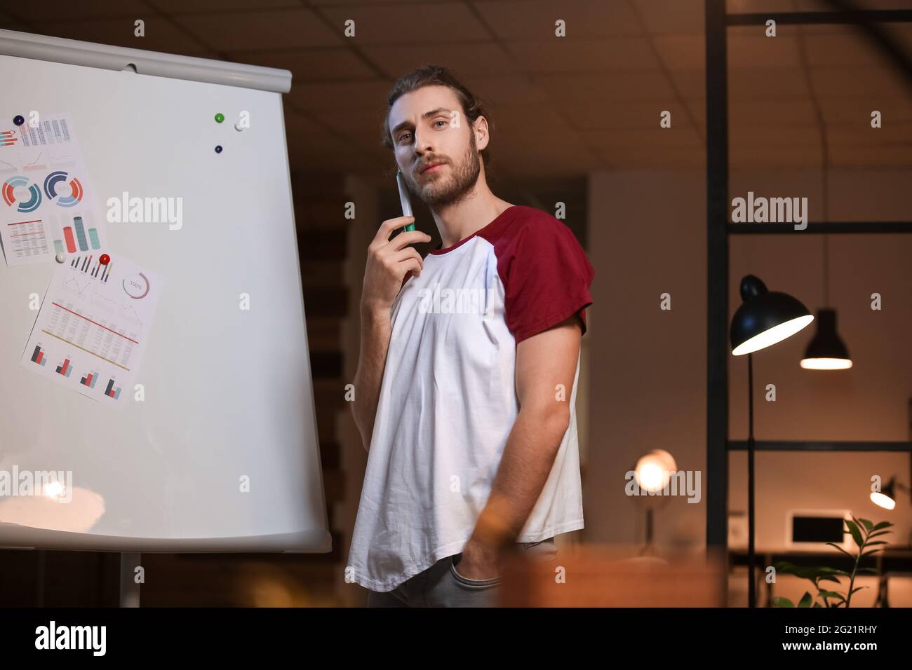 Young man giving presentation in office Stock Photo - Alamy