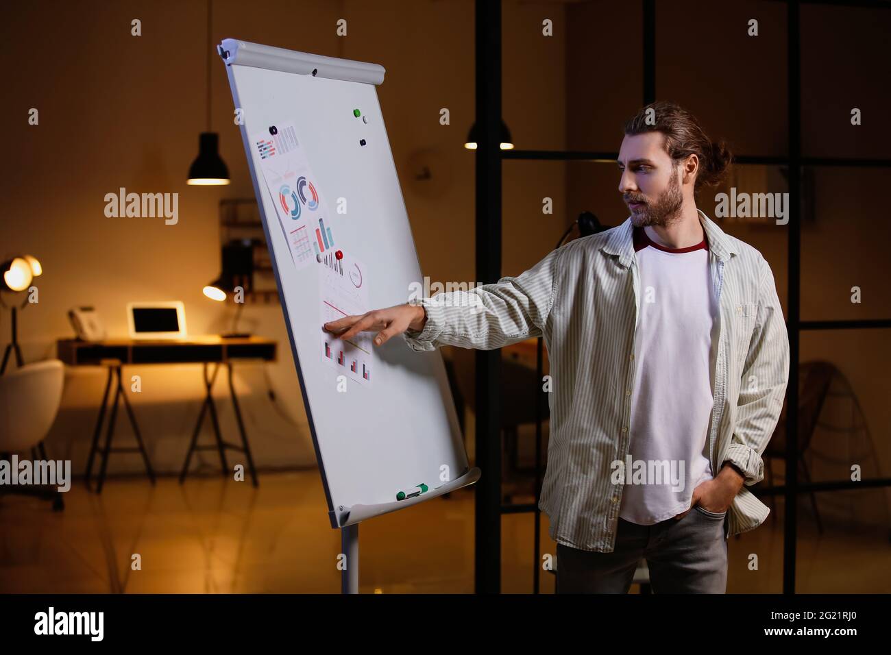 Young man giving presentation in office Stock Photo - Alamy